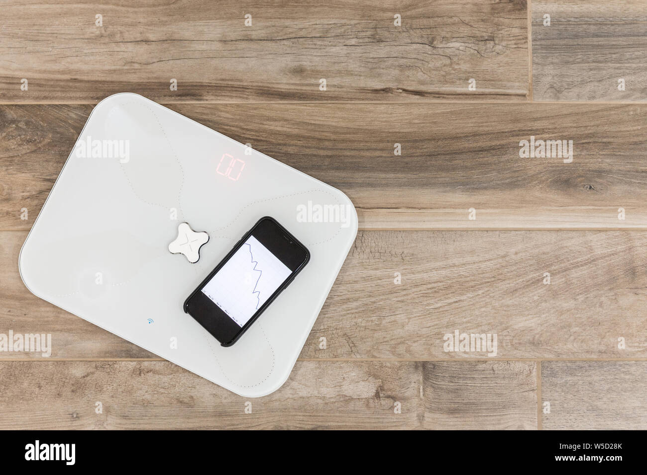 Smart scale standing on a floor connected to smartphone Stock Photo - Alamy
