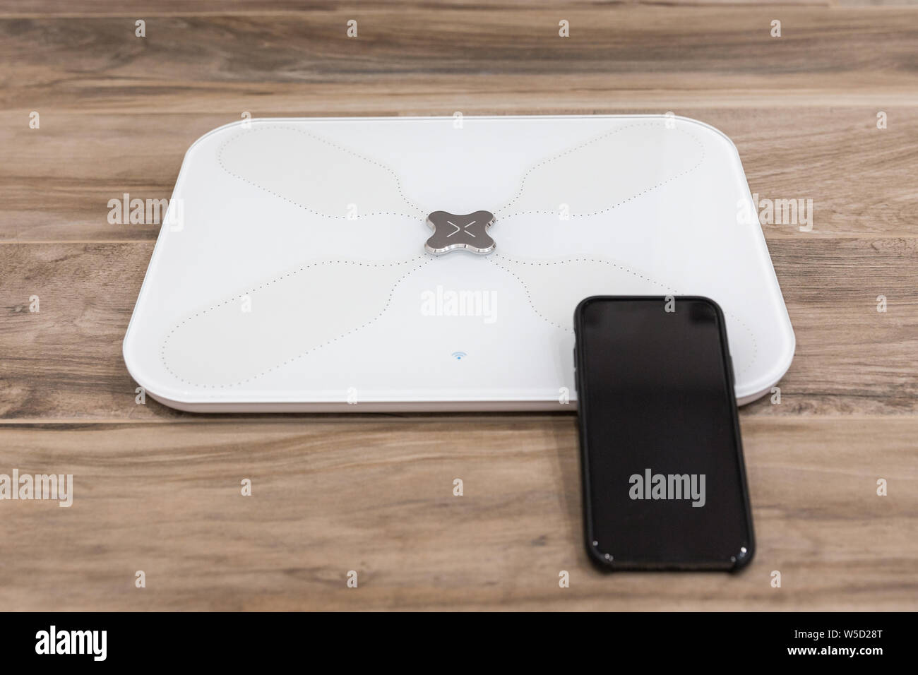 Smart scale standing on a floor connected to smartphone Stock Photo - Alamy