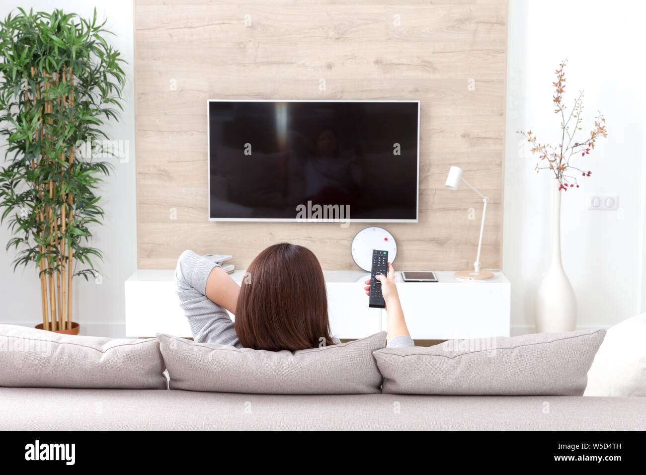 Young woman watching TV in the room Stock Photo - Alamy