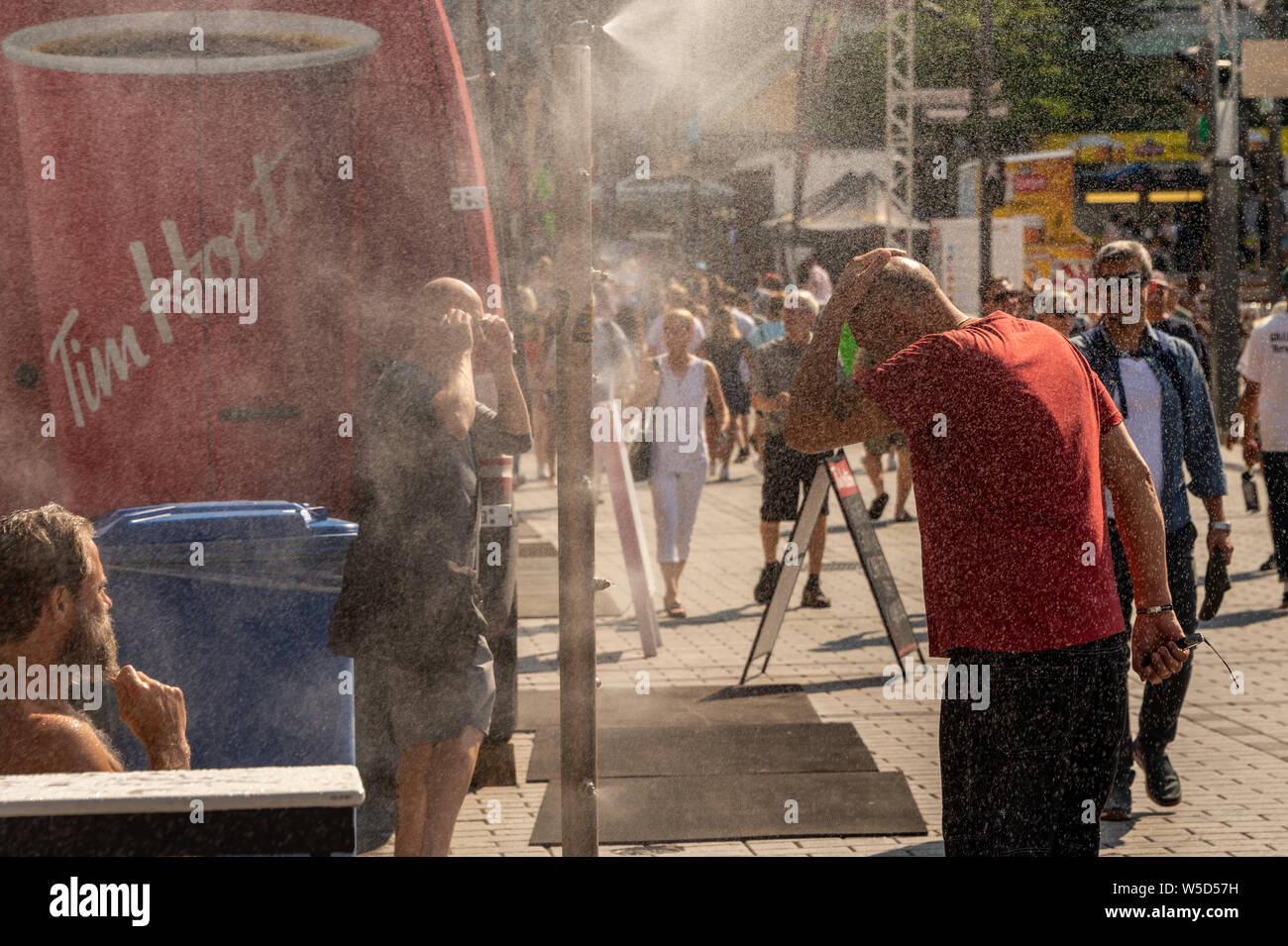 Montreal, CA - 27 July 2019: People walking under misting system to ...