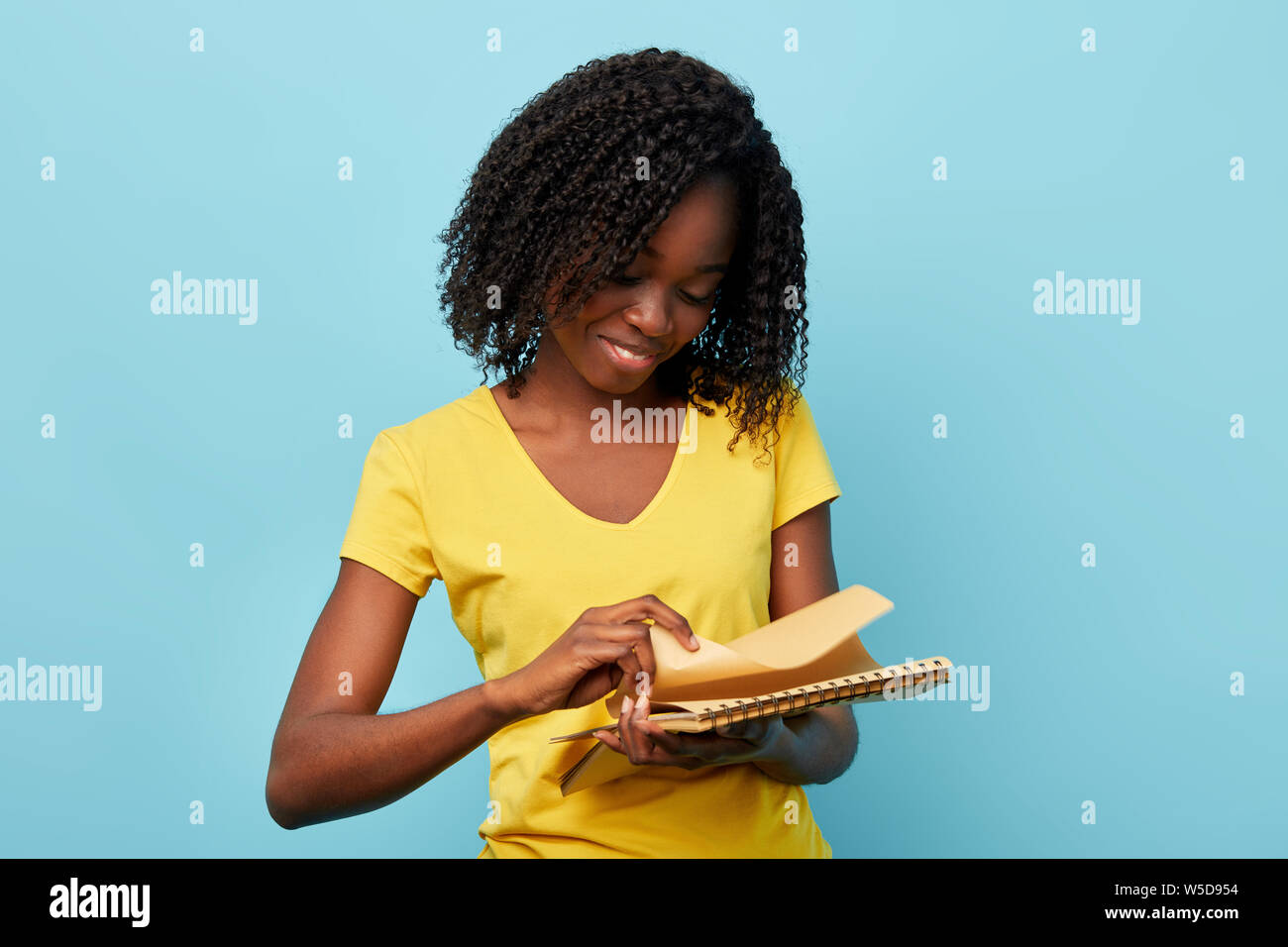 beautiful woman holding notepad and turning page, works on writing new ...