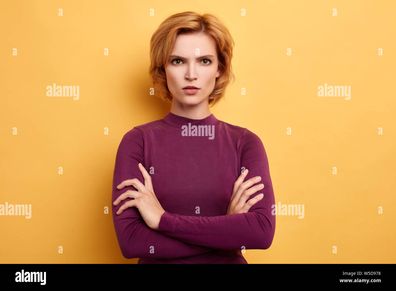 Angry annoyed youngwoman keeping arms crossed and staring at camera ...