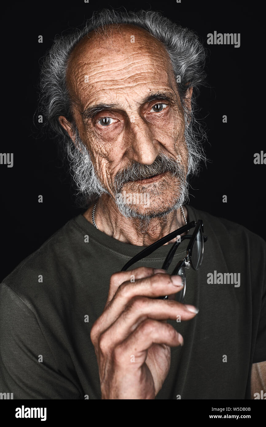 close up portrait of senior man in glasses taking off glasses, old age ...