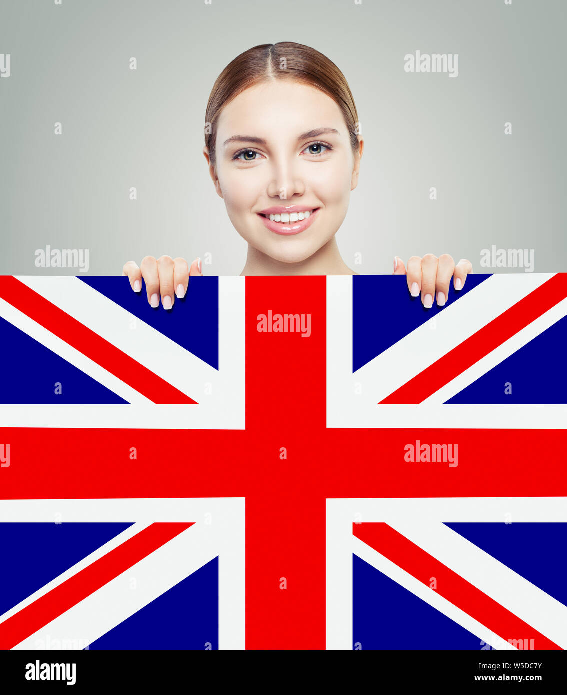 Portrait of happy pretty girl with UK flag background. Young woman ...