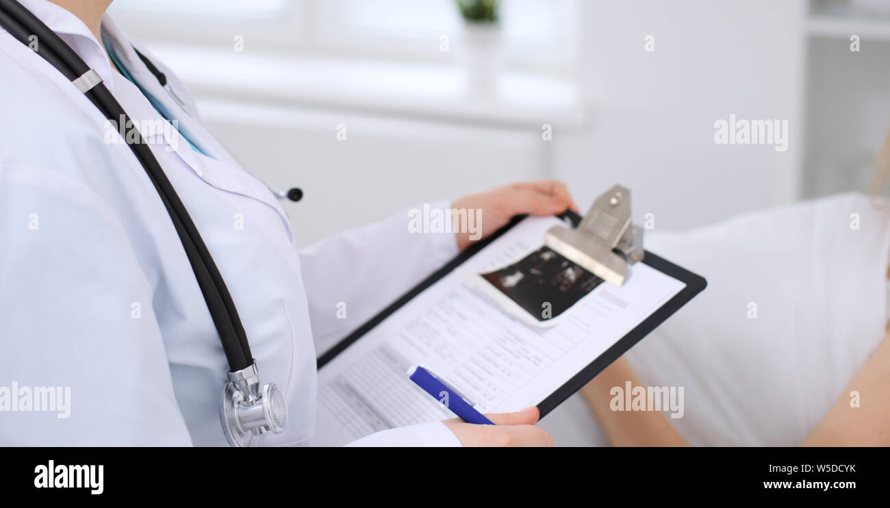 Female doctor holding application form while consulting patient Stock ...