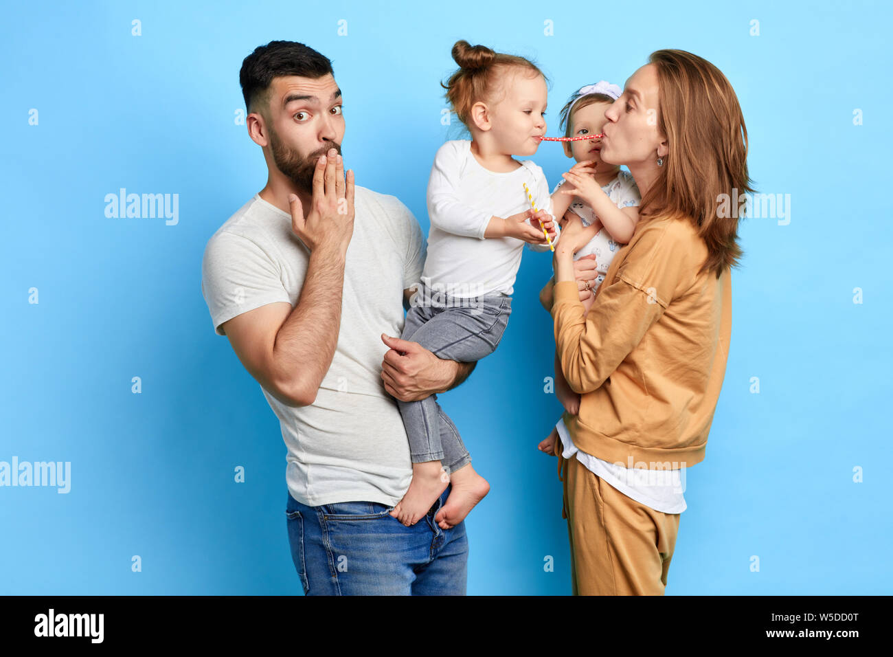 caring mother eating and her little daughter eating sweety stick while ...