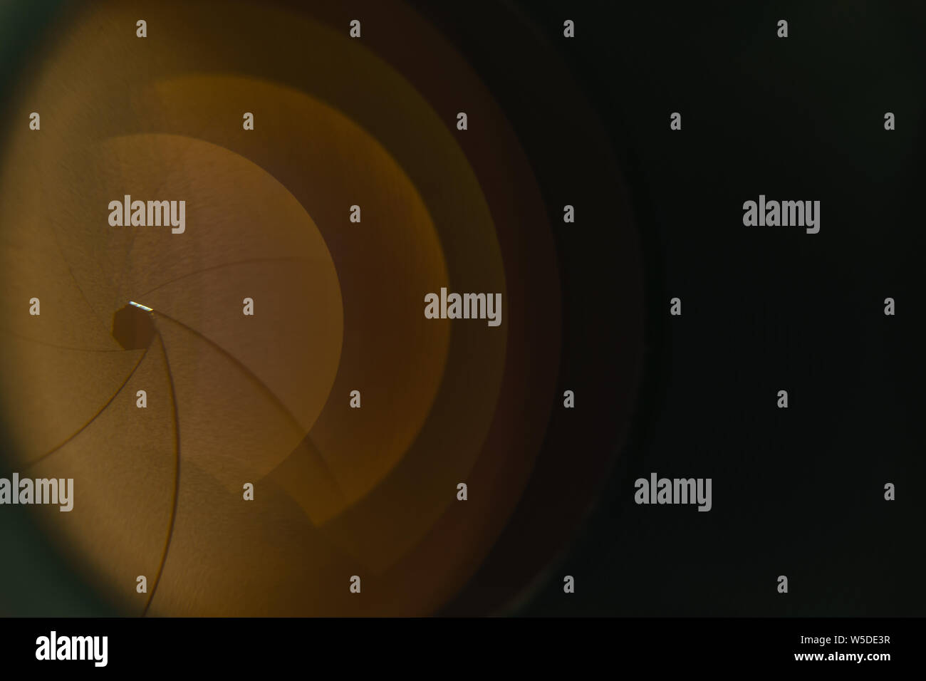 Beautiful camera lens with yellow light reflection of glass on a black ...