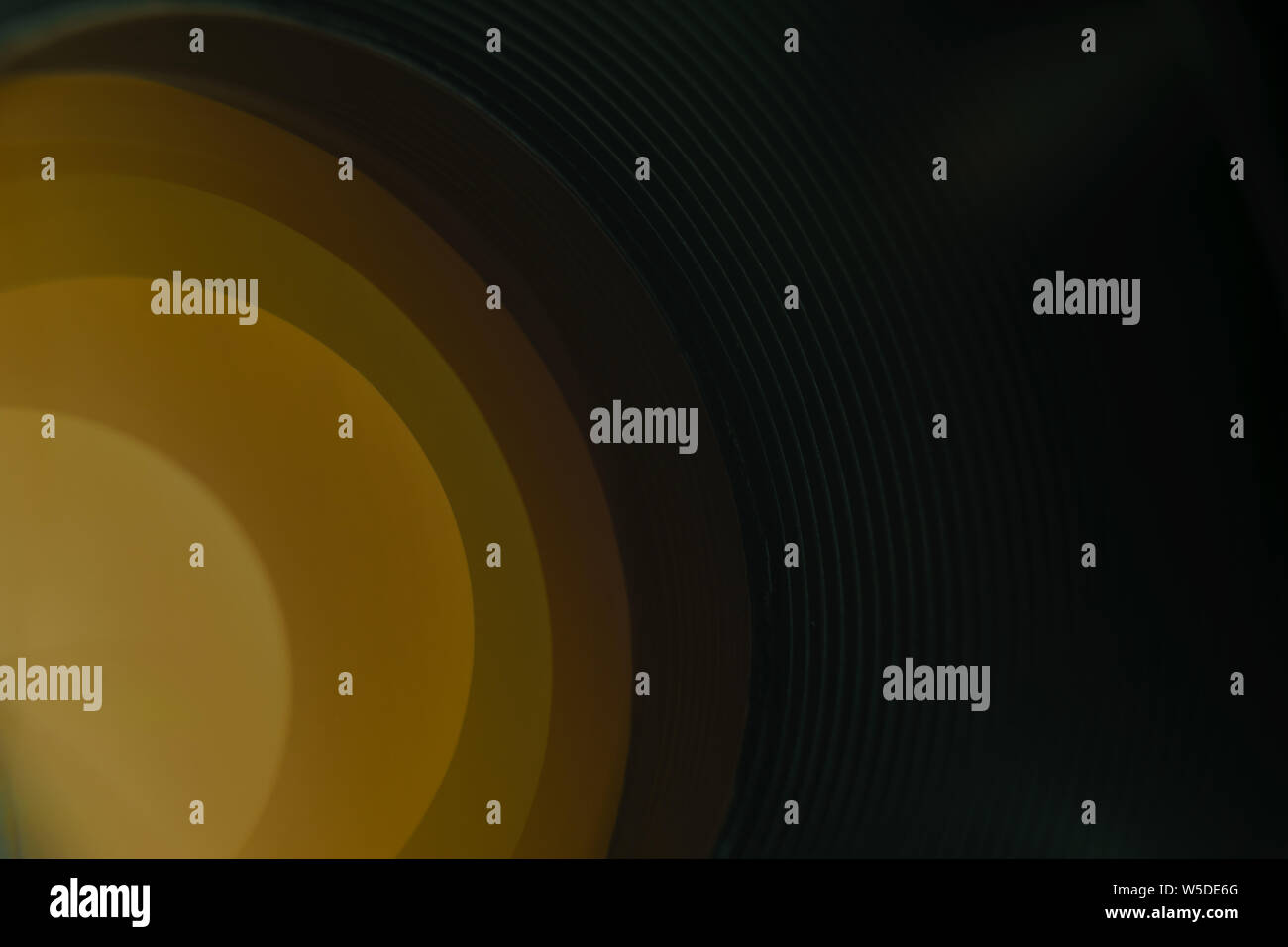 Beautiful camera lens with yellow light reflection of glass on a black ...