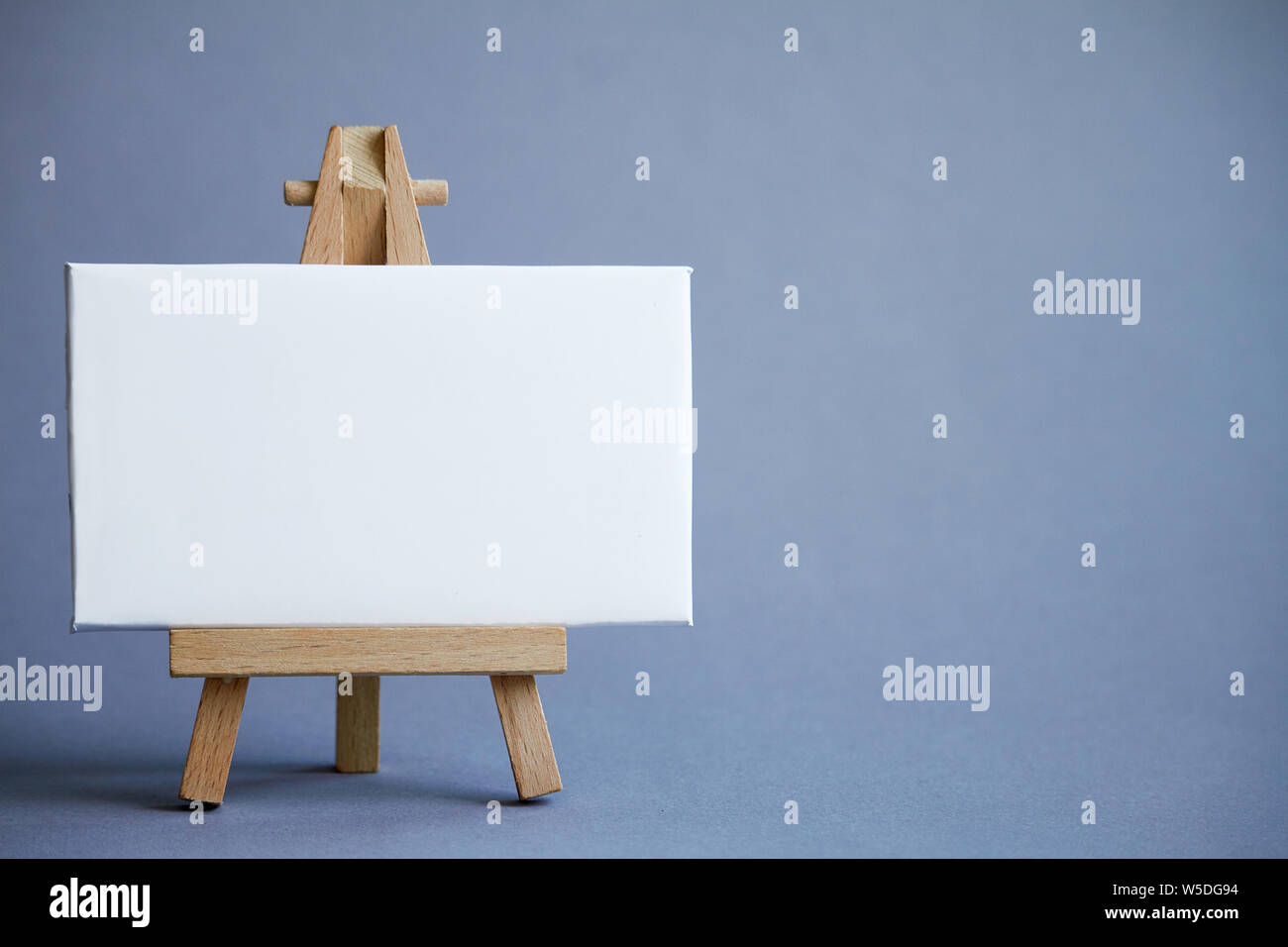Miniature easel with a white board for writing, pointer on white ...