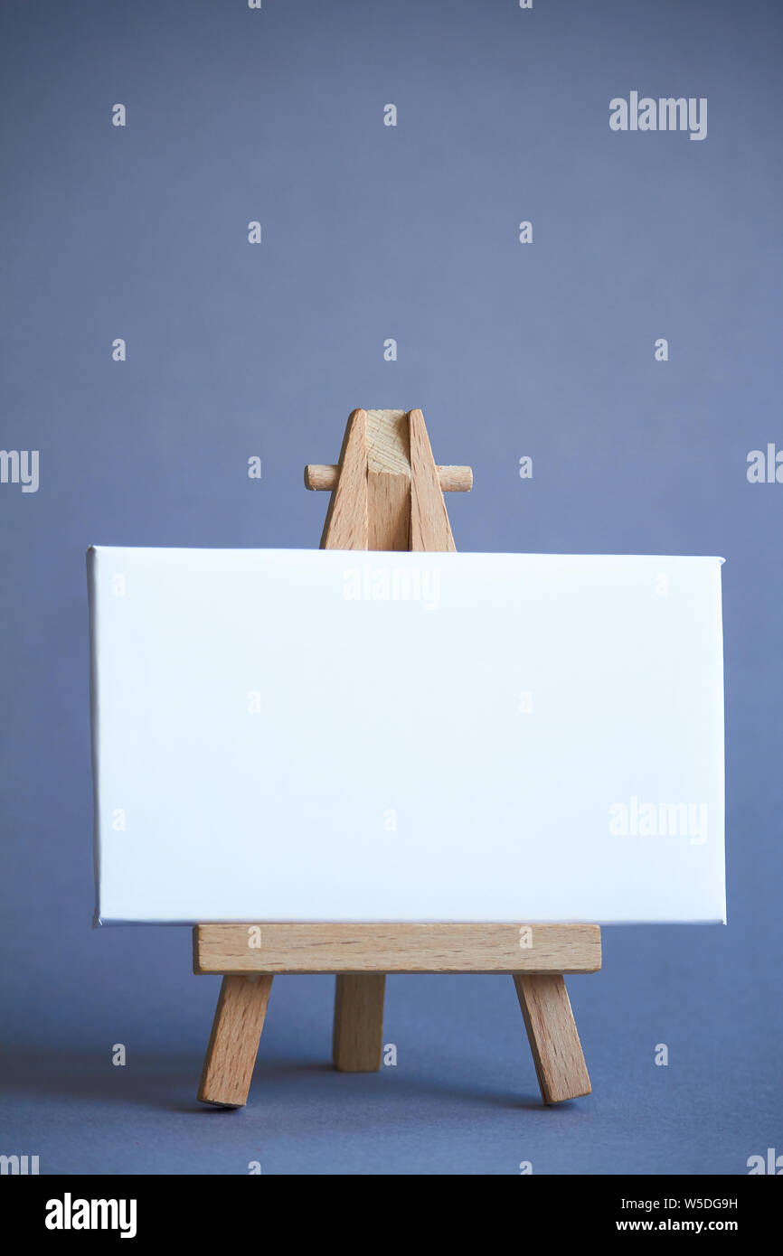 Miniature easel with a white board for writing, pointer on white ...
