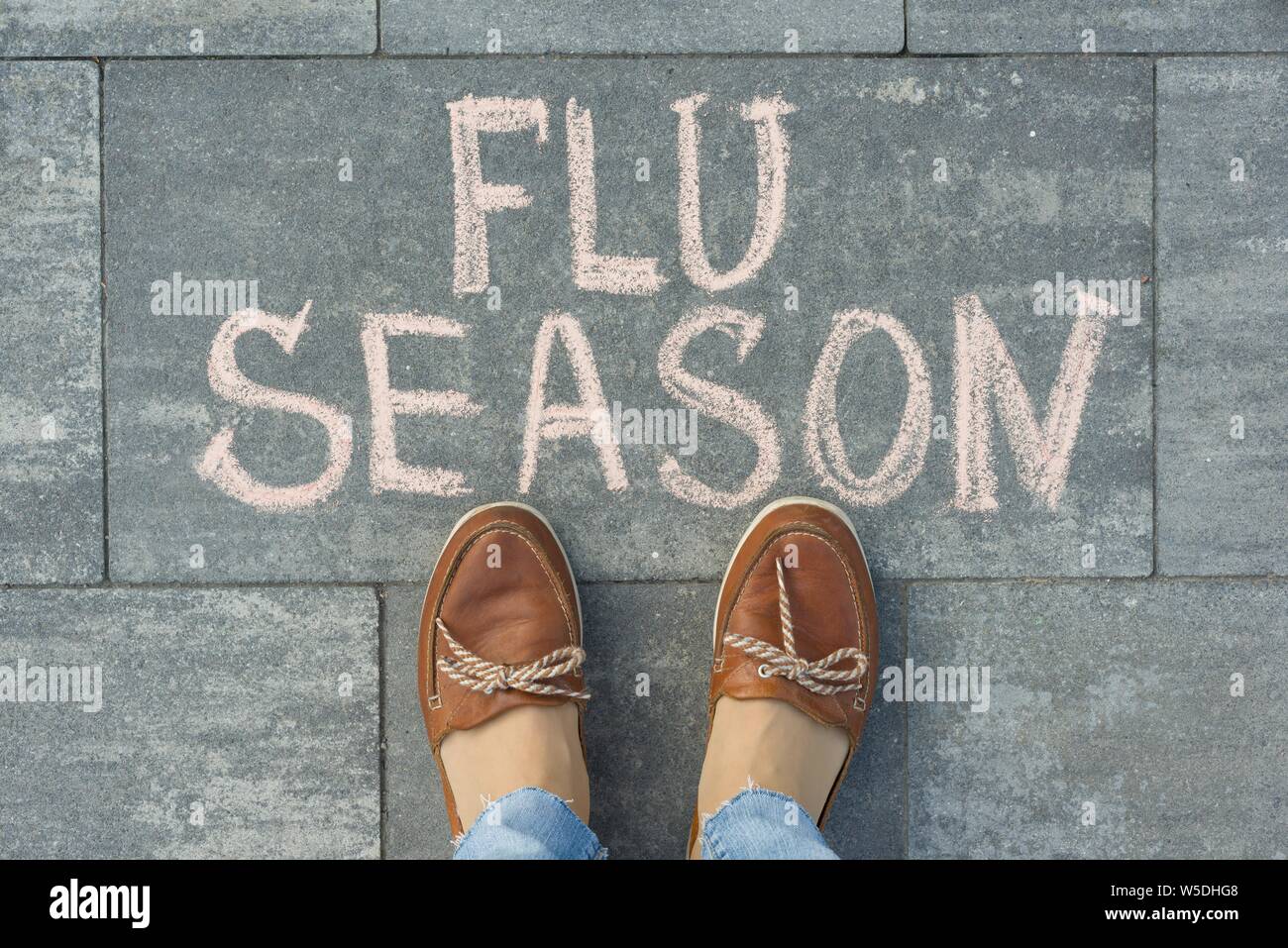 Female feet with text flu season written on grey sidewalk Stock Photo ...
