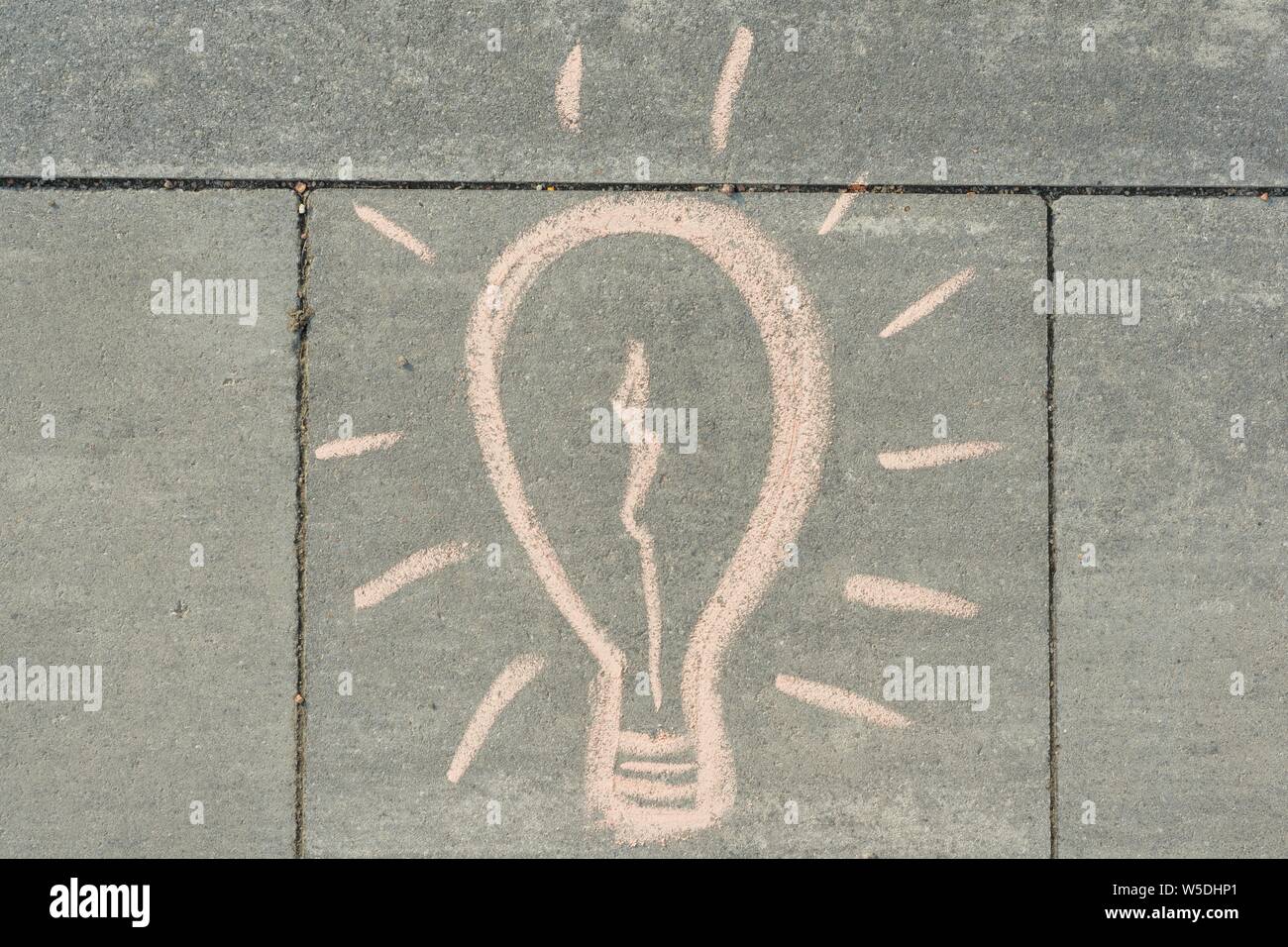 Abstract image drawing of light bulb written on grey sidewalk Stock ...