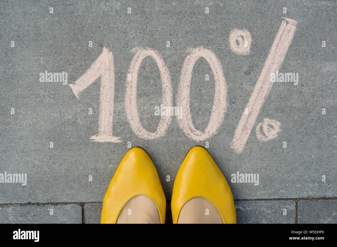Female feet with text 100 percent written on grey sidewalk Stock Photo ...