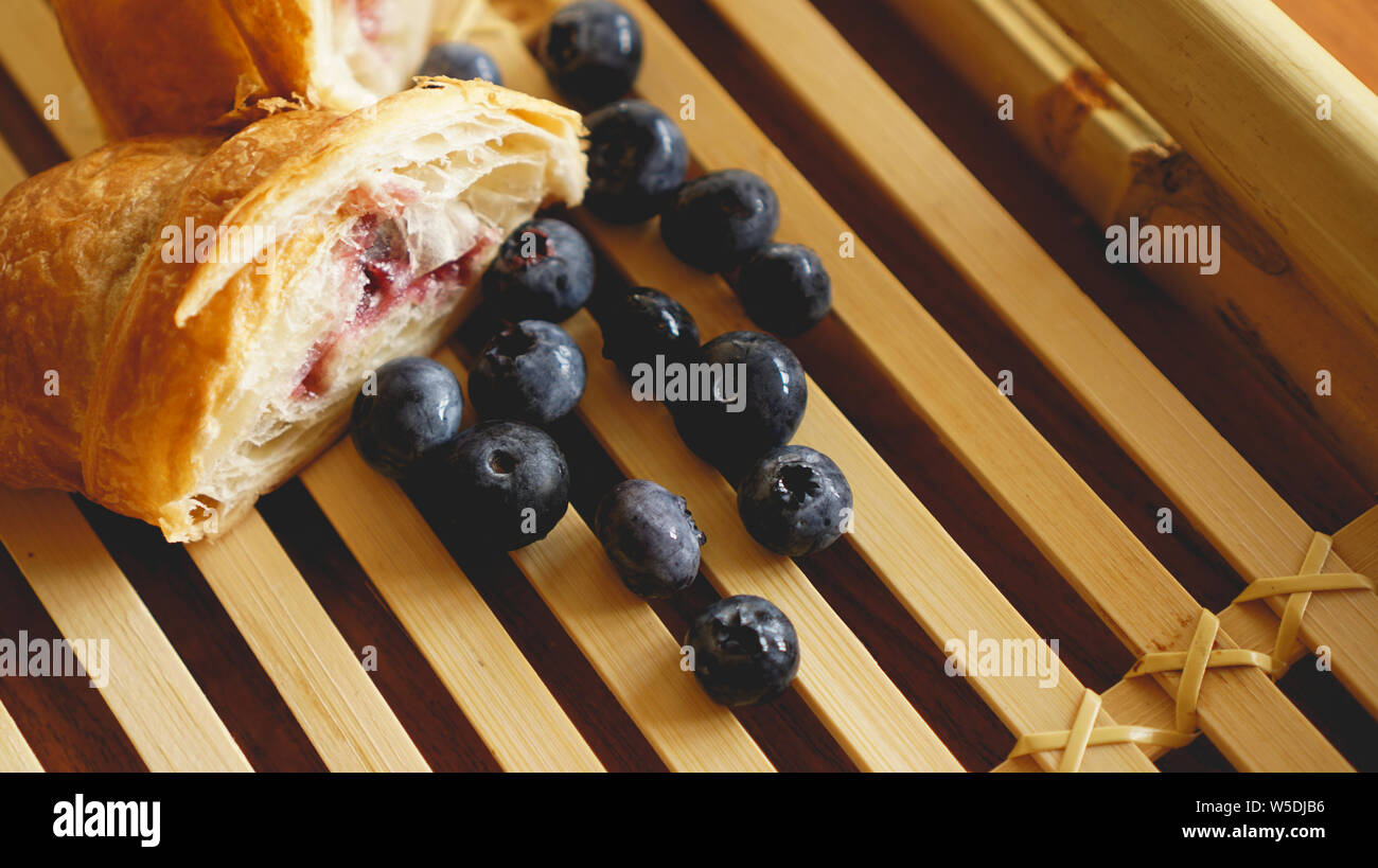 Delicious breakfast with fresh croissant and blueberry on wooden ...