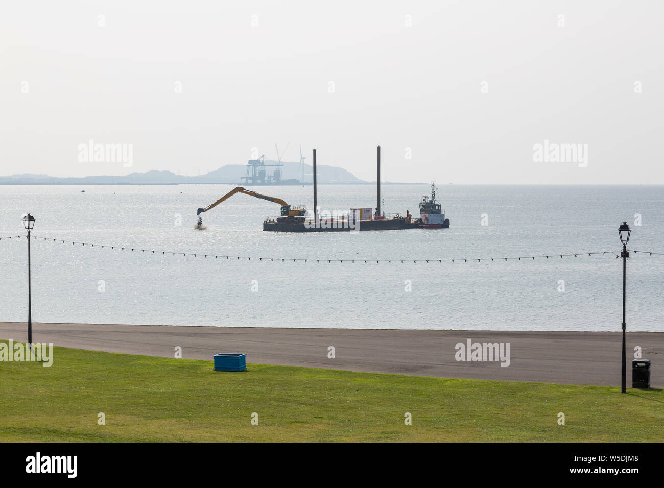 A long reach digger working from a barge to install a longer screened ...