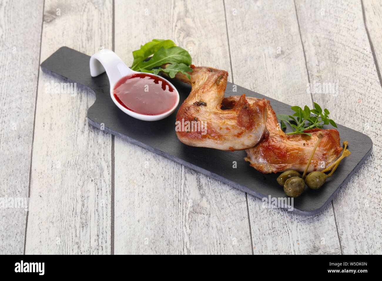 Roasted rabbit legs with cowberry sauce Stock Photo - Alamy