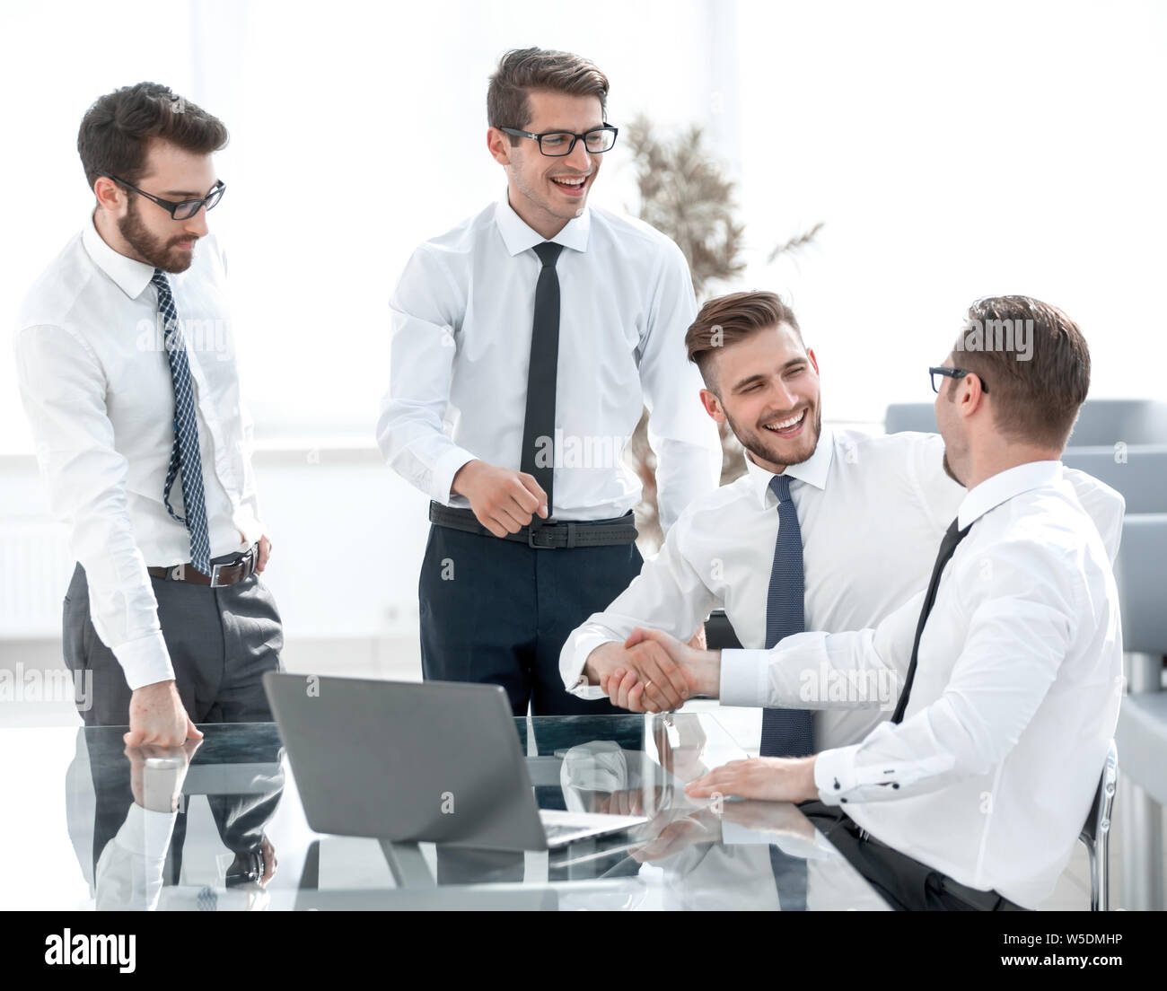 happy employees shaking hands Stock Photo - Alamy