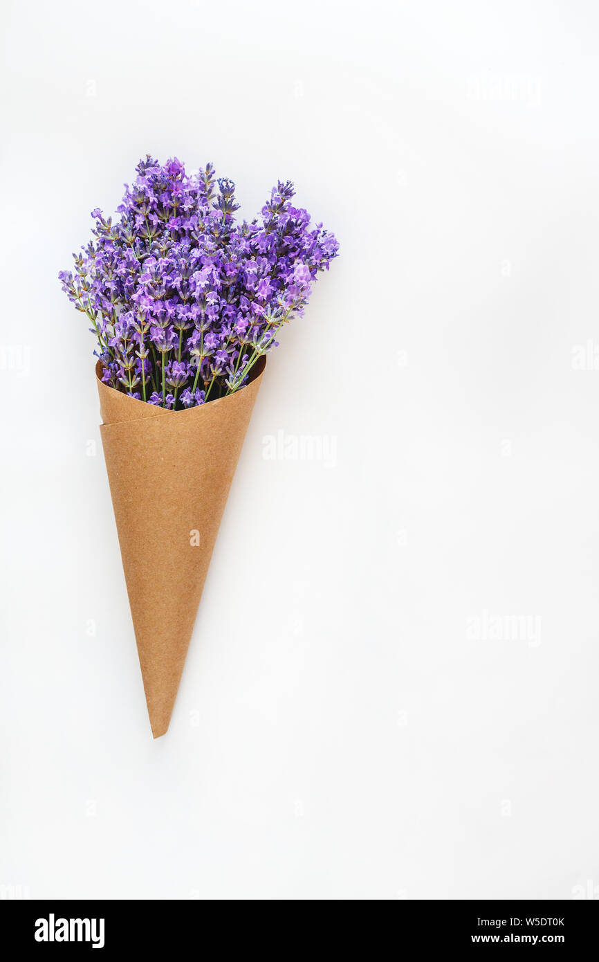 lavender flowers bouquet in parchment paper cone on a white isolated ...