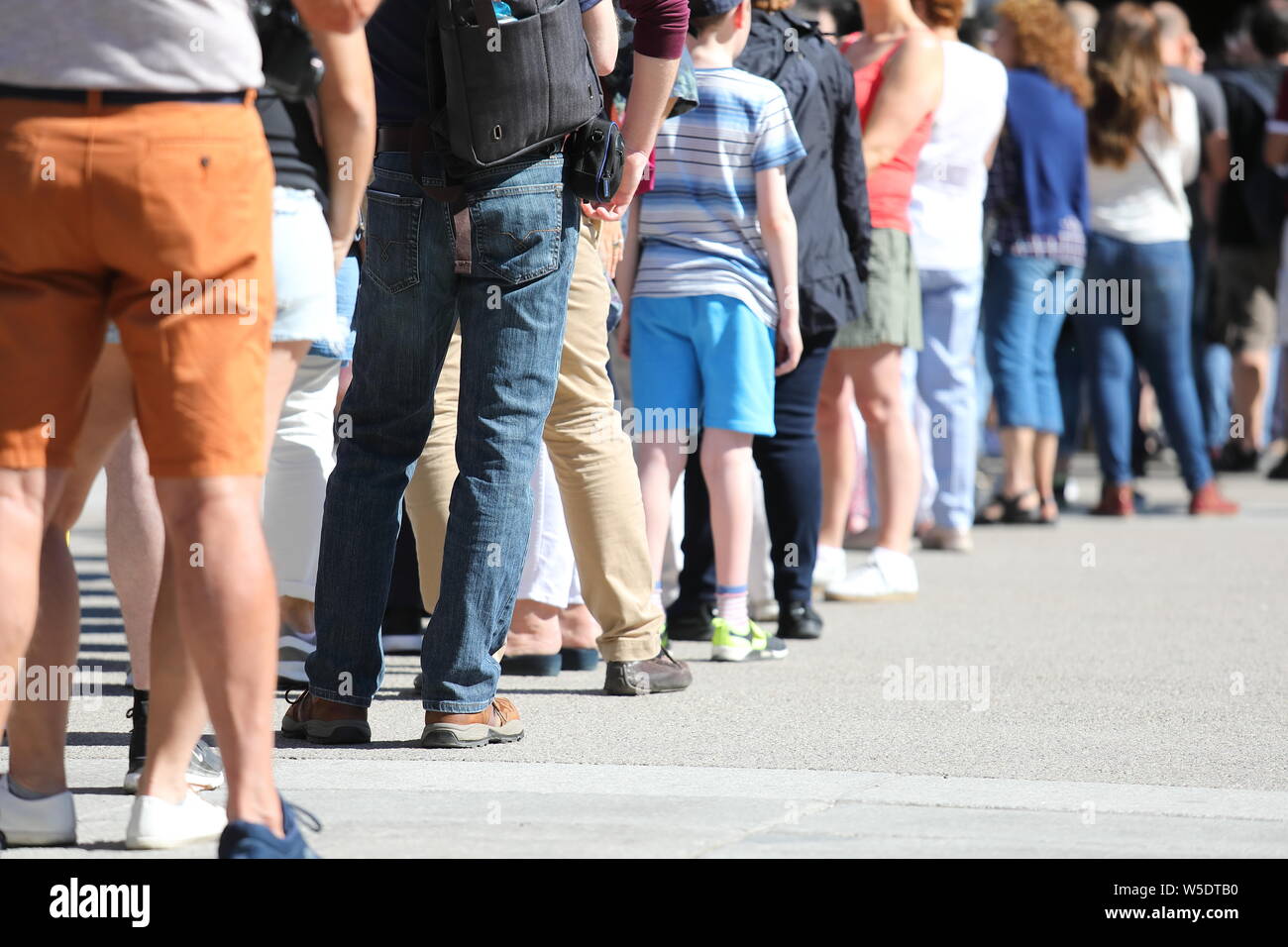 Long queue of people waiting in line Stock Photo - Alamy