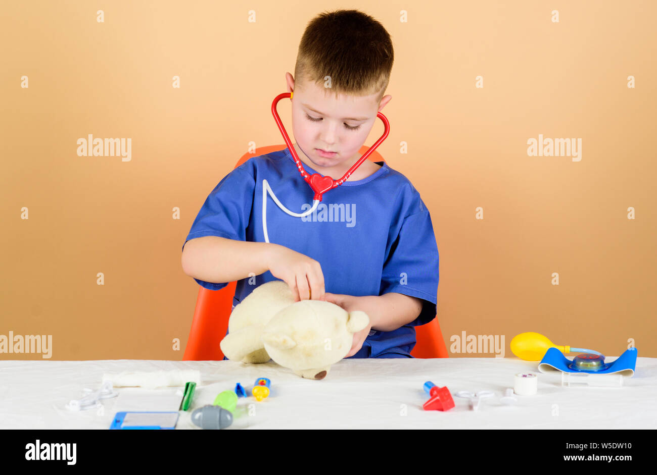 Kid little doctor busy sit table with medical tools. Medical ...