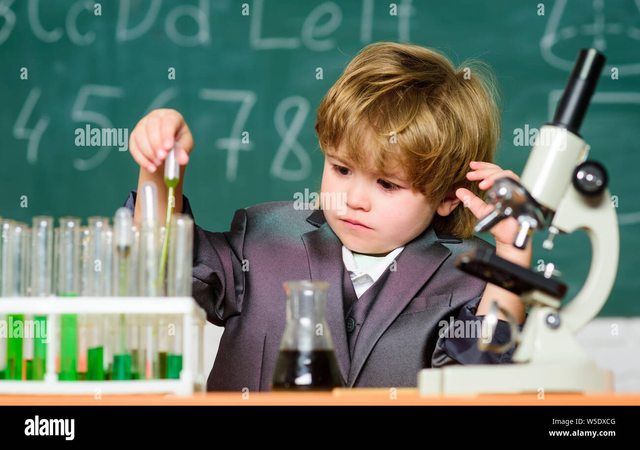 little boy at lesson. Back to school. Little boy is making science ...