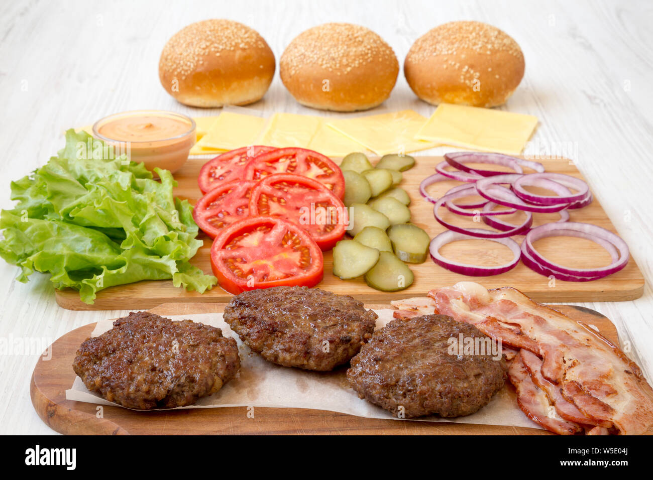 Burger ingredients on a white wooden background, side view. Close-up ...