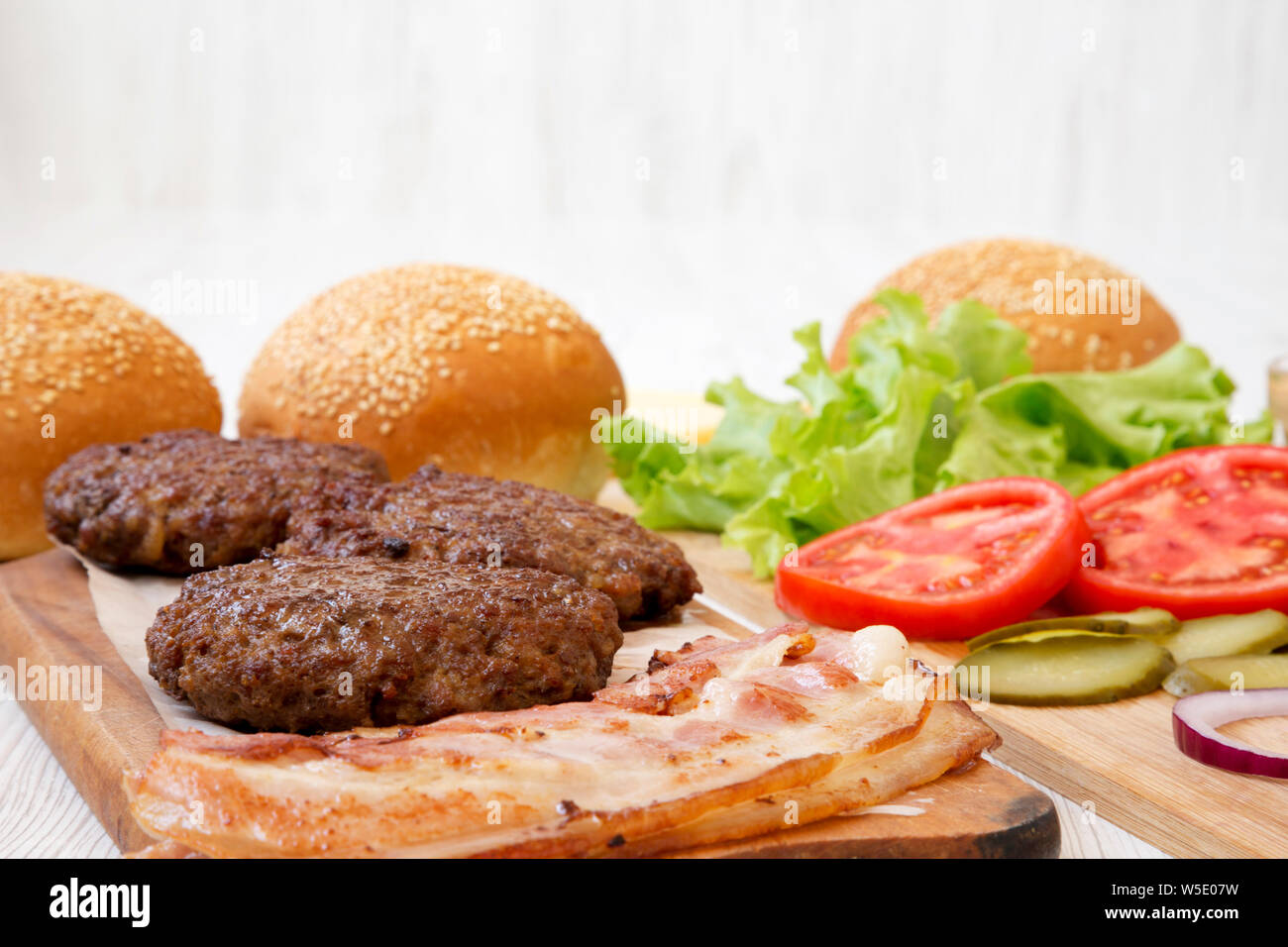 Burger ingredients on a white wooden surface, side view. Close-up Stock ...