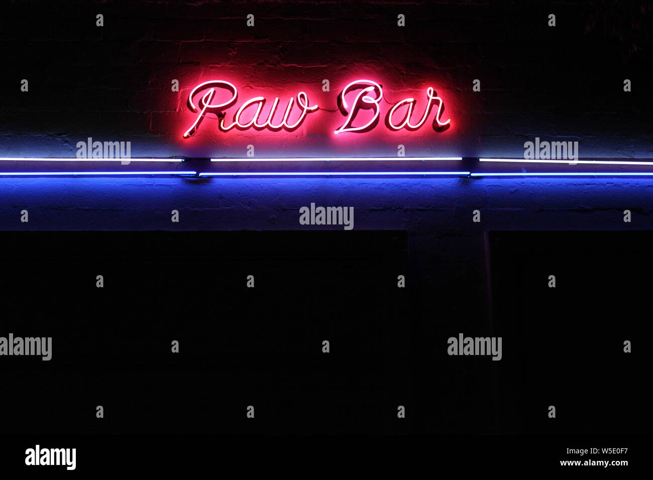 Bright neon sign writing raw bar Stock Photo - Alamy