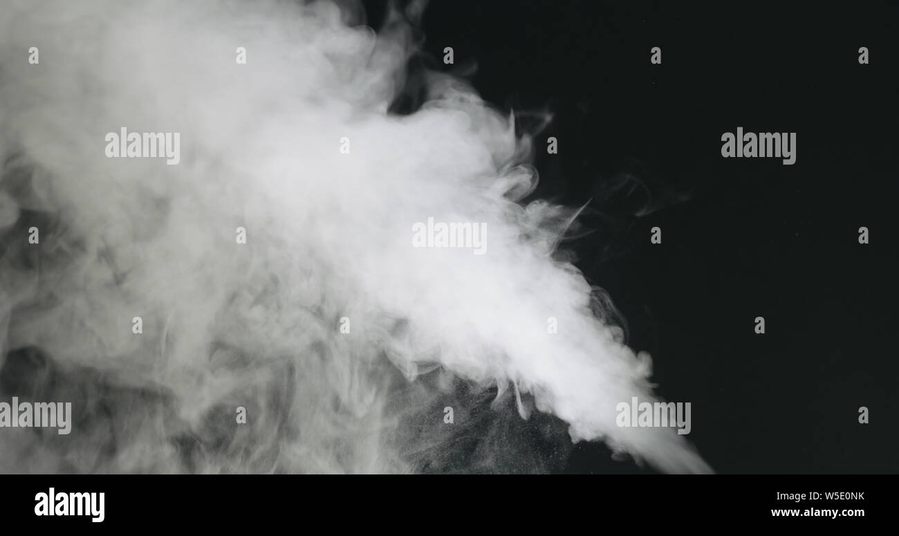 water vapor stream comes from below over black background with motion ...