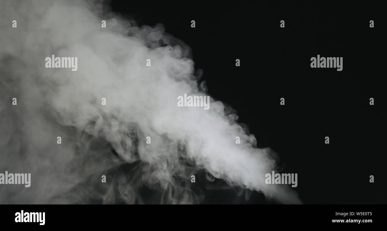 water vapor stream comes from below over black background with motion ...