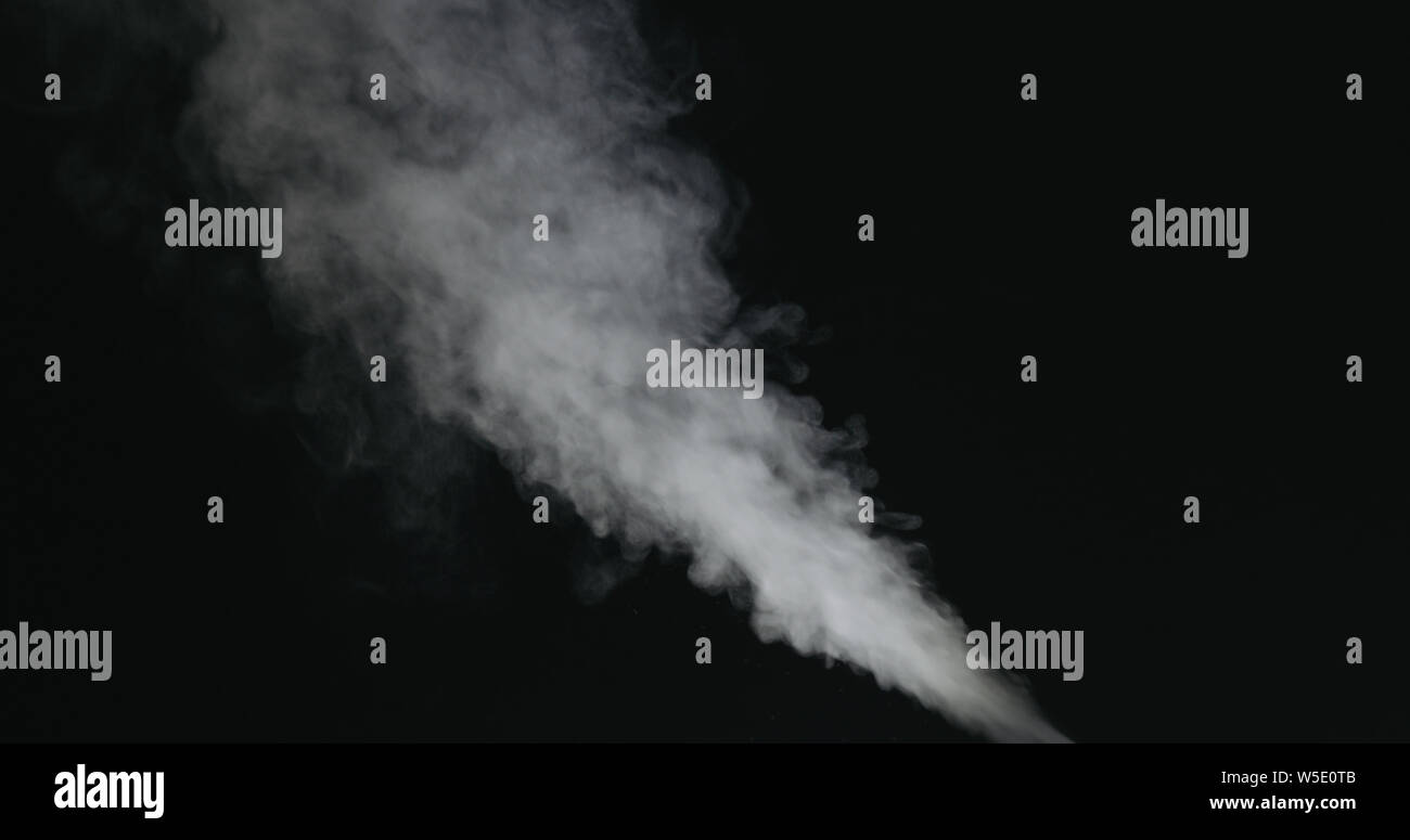 water vapor stream comes from below over black background with motion ...