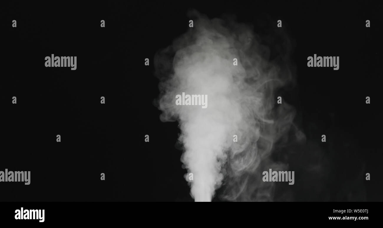 water vapor stream comes from below over black background with motion ...