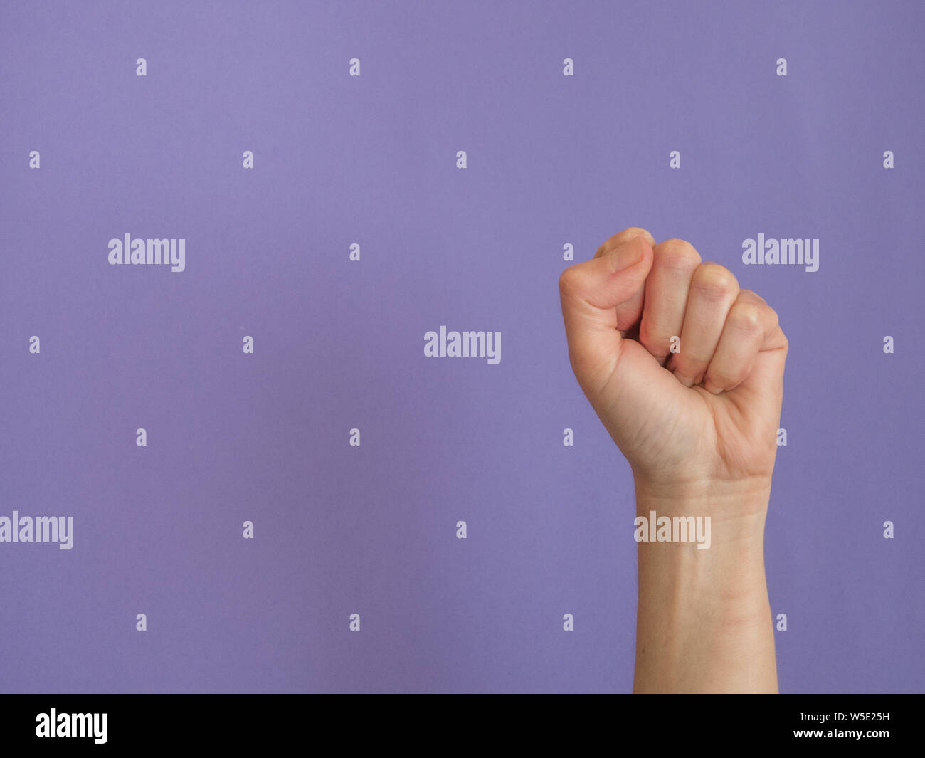 Hand with clenched fist on purple background with copy space Stock ...