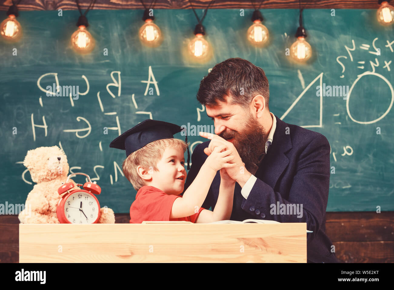 Kid cheerful distracting while studying, attention deficit. Father with ...