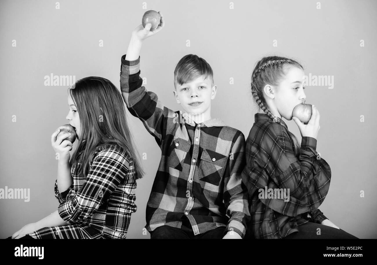 Healthy dieting and vitamin nutrition. Boy and girls friends eat apple ...