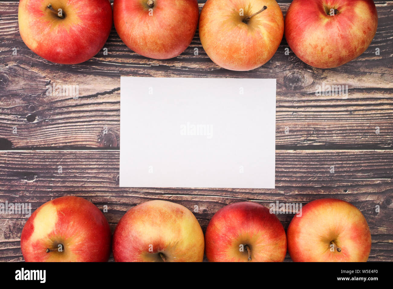 Fresh red apples and white paper on the wooden background Stock Photo ...