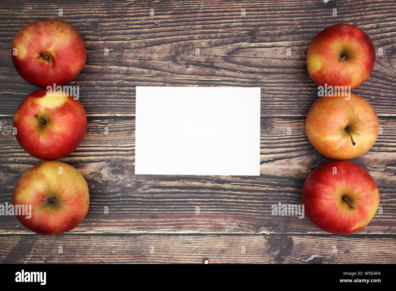 Fresh red apples and white paper on the wooden background Stock Photo ...