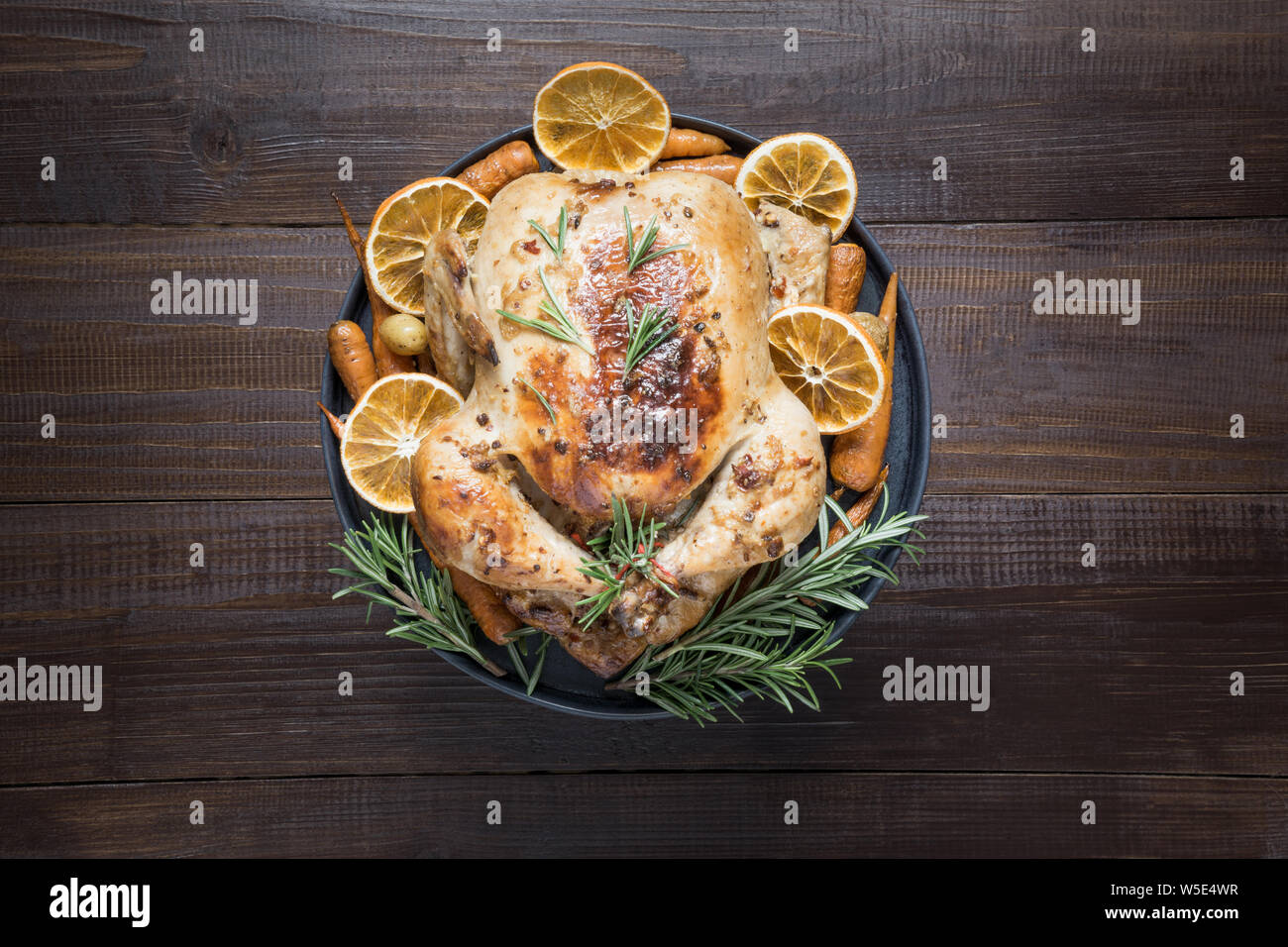 Traditional roasted turkey garnish rosemary and sliced orange on dark ...