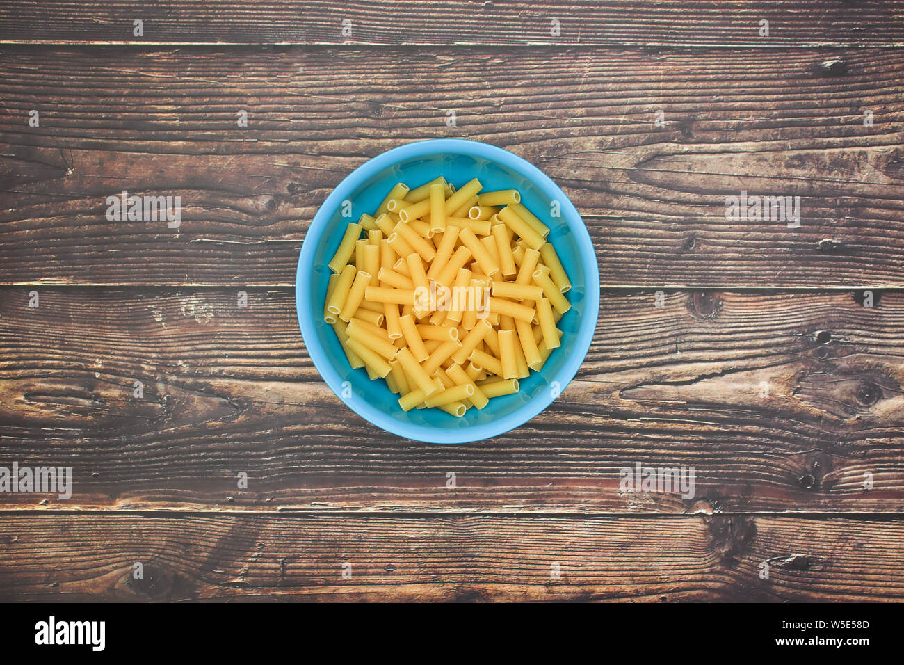 Raw penne pasta on blue background hi-res stock photography and images ...
