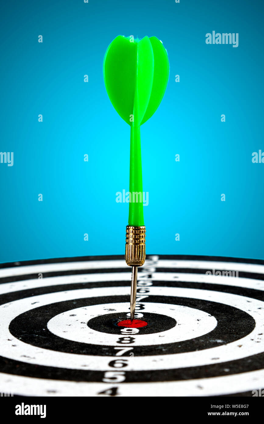 Aim with arrow in the center. Aim on blue background with green dart ...