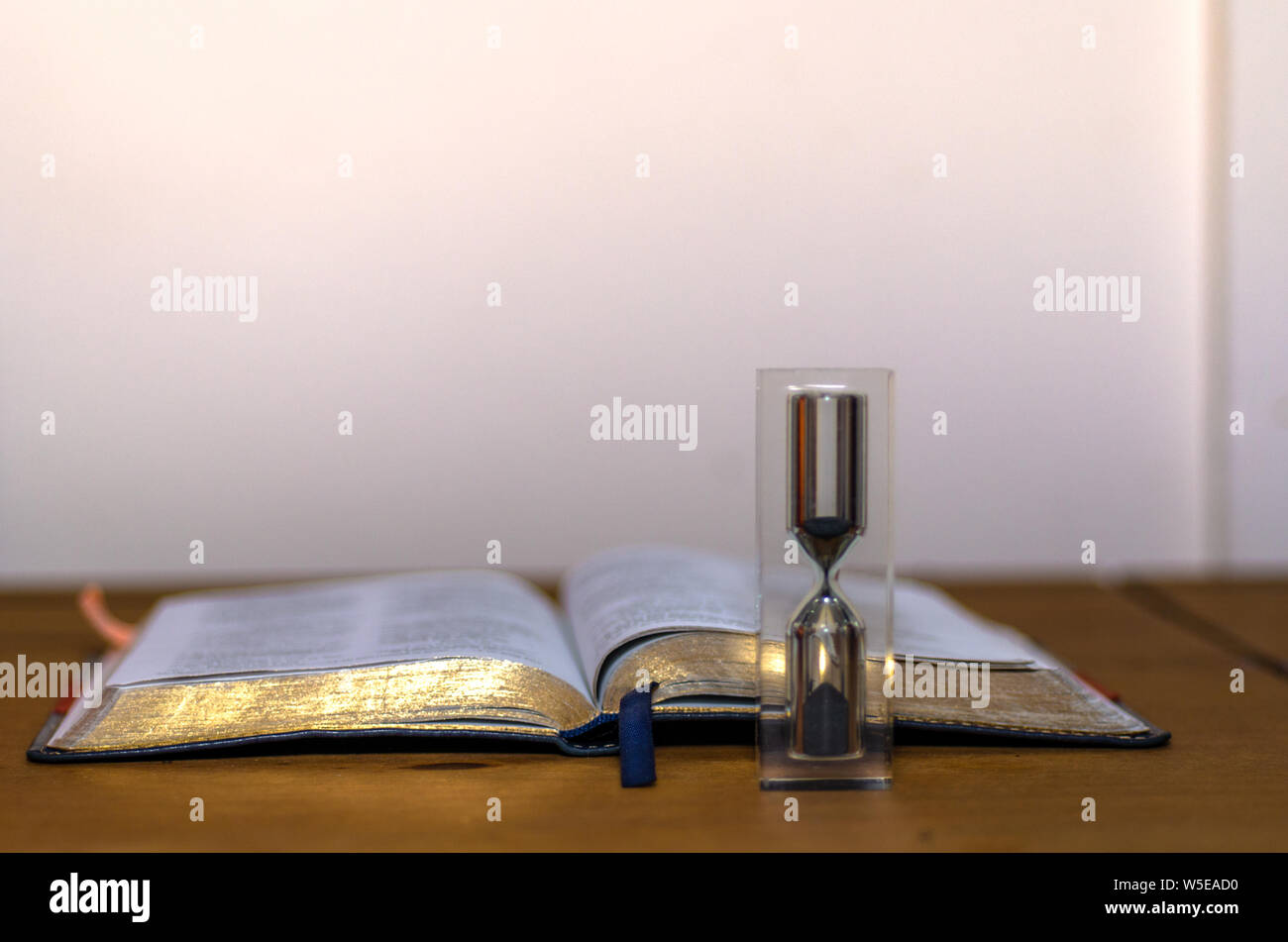 An open bible by an hour glass Stock Photo - Alamy