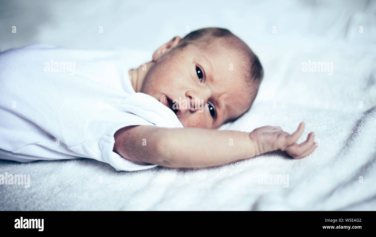 cute newborn baby lying peacefully in the crib .the photo has a empty ...