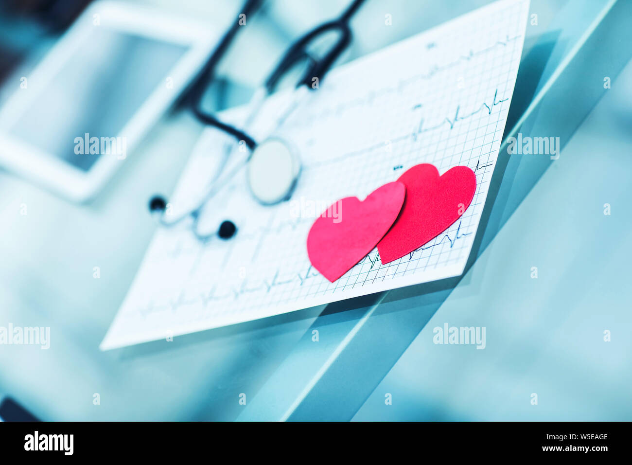 two red paper heart on the electrocardiogram, the cardiologist.the ...
