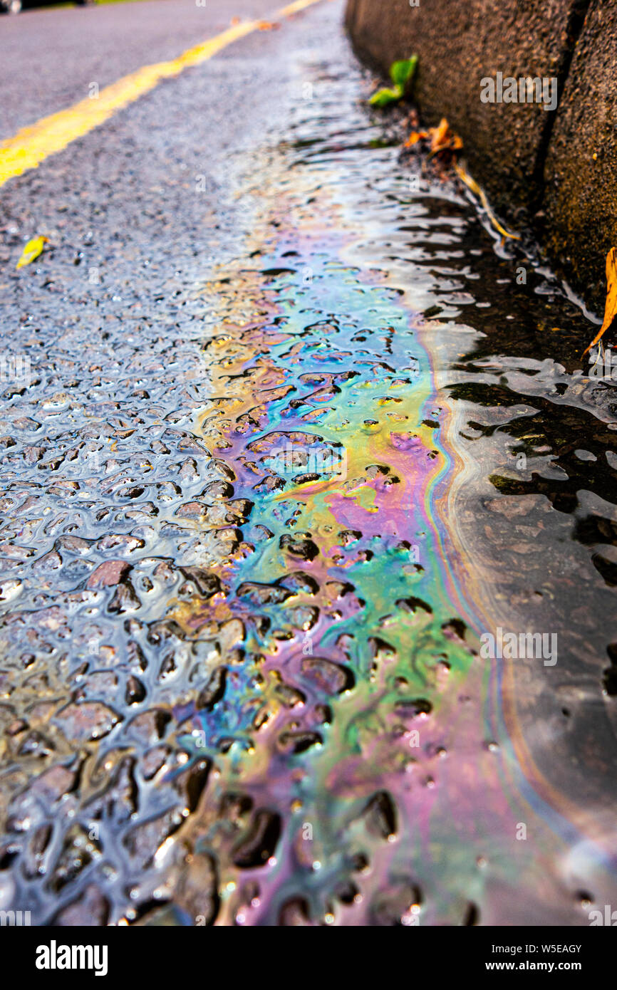 Spilt Petrol Gasoline Oil Running Down a Drain On a Road Gutter ...