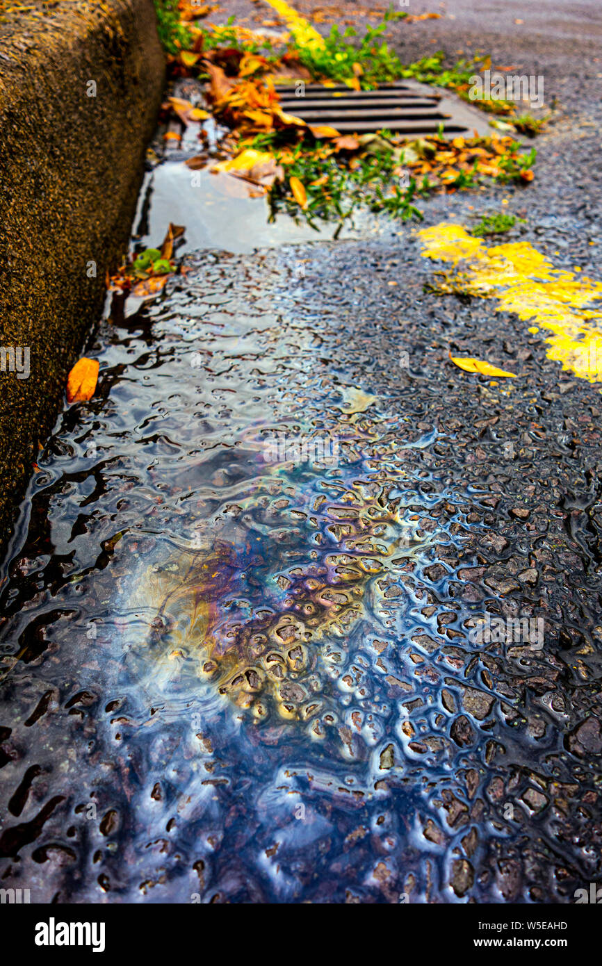 Spilt Petrol Gasoline Oil Running Down a Drain On a Road Gutter ...