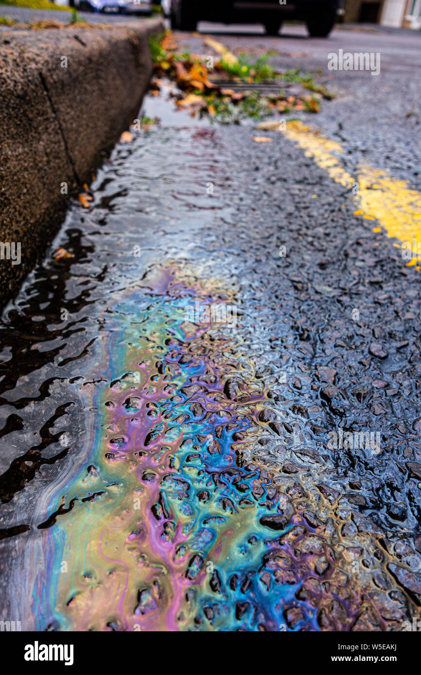 Spilt Petrol Gasoline Oil Running Down a Drain On a Road Gutter ...
