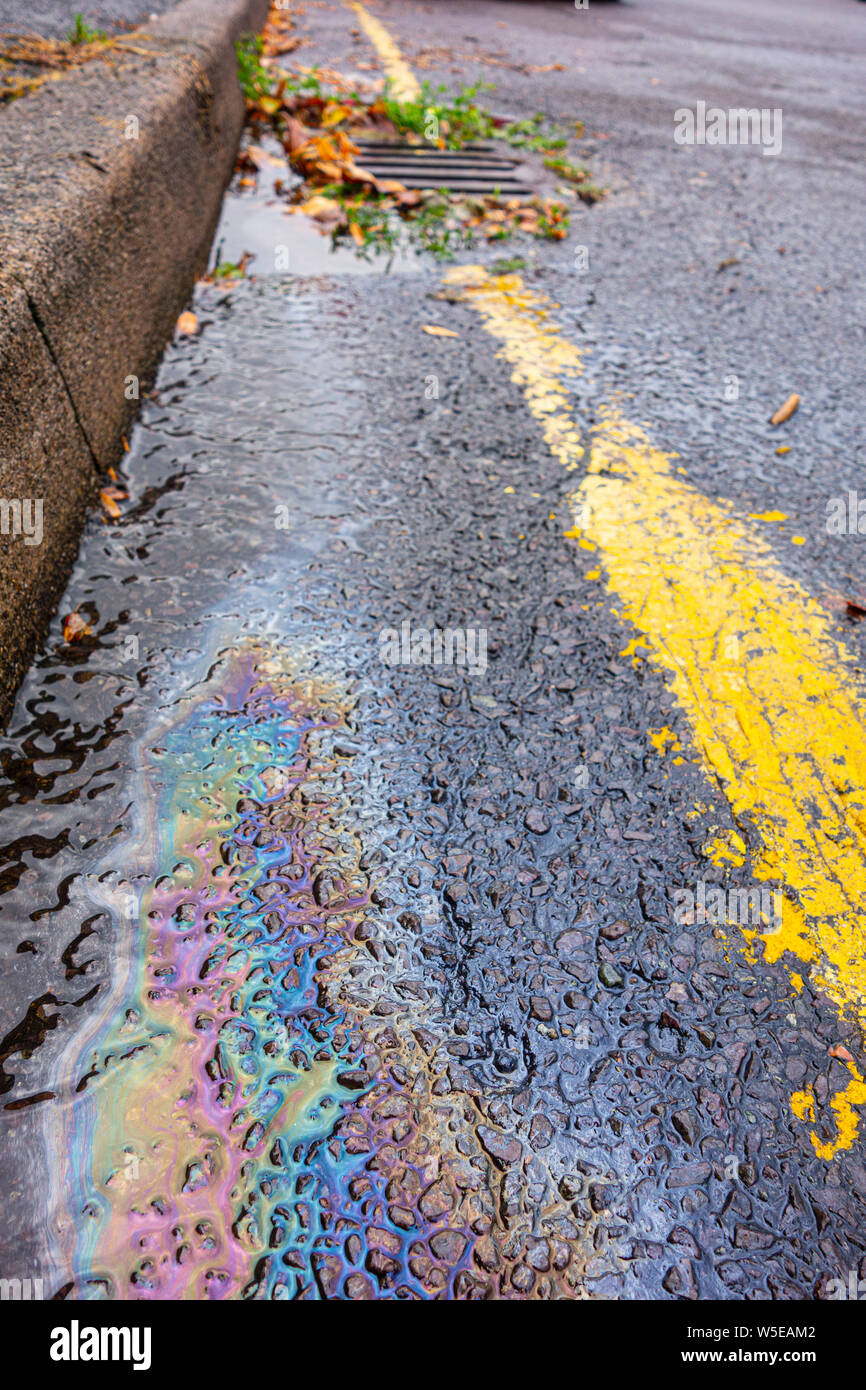 Spilt Petrol Gasoline Oil Running Down a Drain On a Road Gutter ...