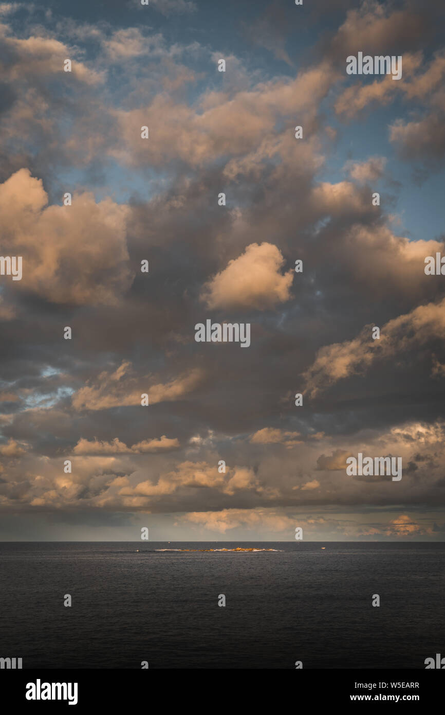 Moody sunset clouds hanging over Wedding Cake Island off Coogee Beach ...