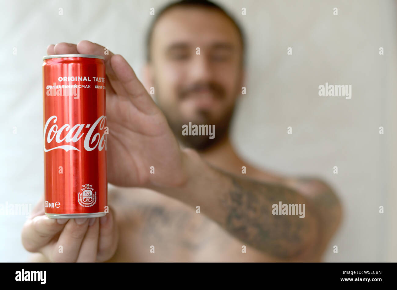 KHARKIV, UKRAINE - JULY 15, 2019: Smiling man presents non-alcoholic ...