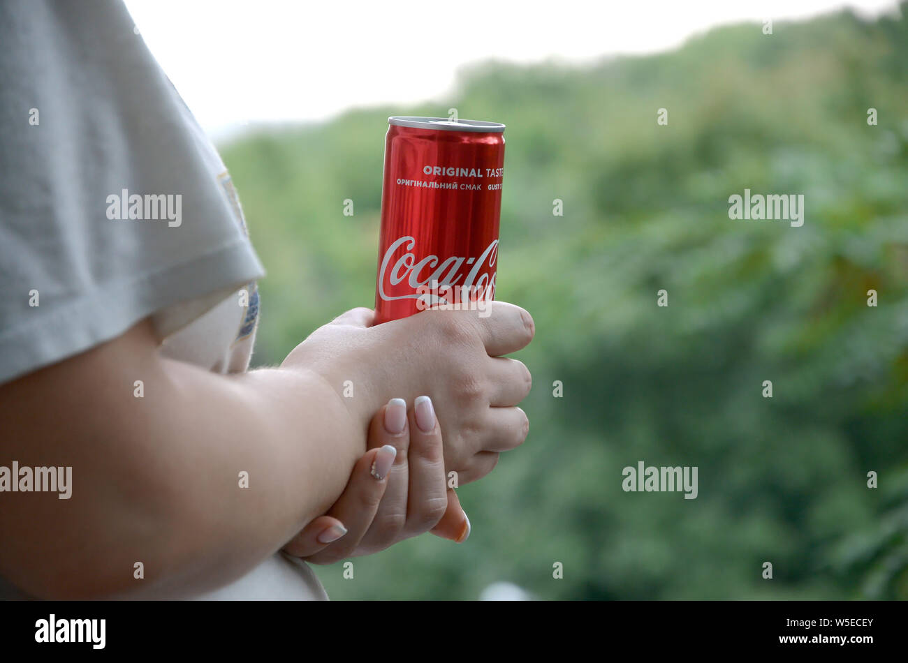 KHARKIV, UKRAINE - JULY 15, 2019: Caucasian woman holds red Coca-Cola ...
